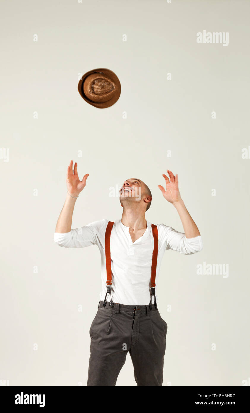 man throws his hat in air, portrait in studio Stock Photo - Alamy