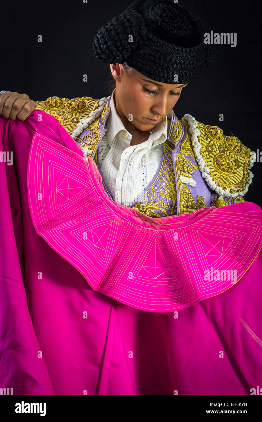 Woman bullfighter holding capote pink on black background Stock Photo ...