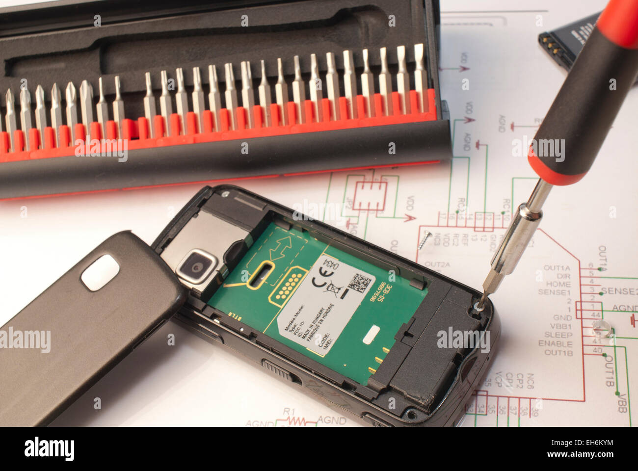A smartphone rests on an electrical diagram while it is being repaired ...