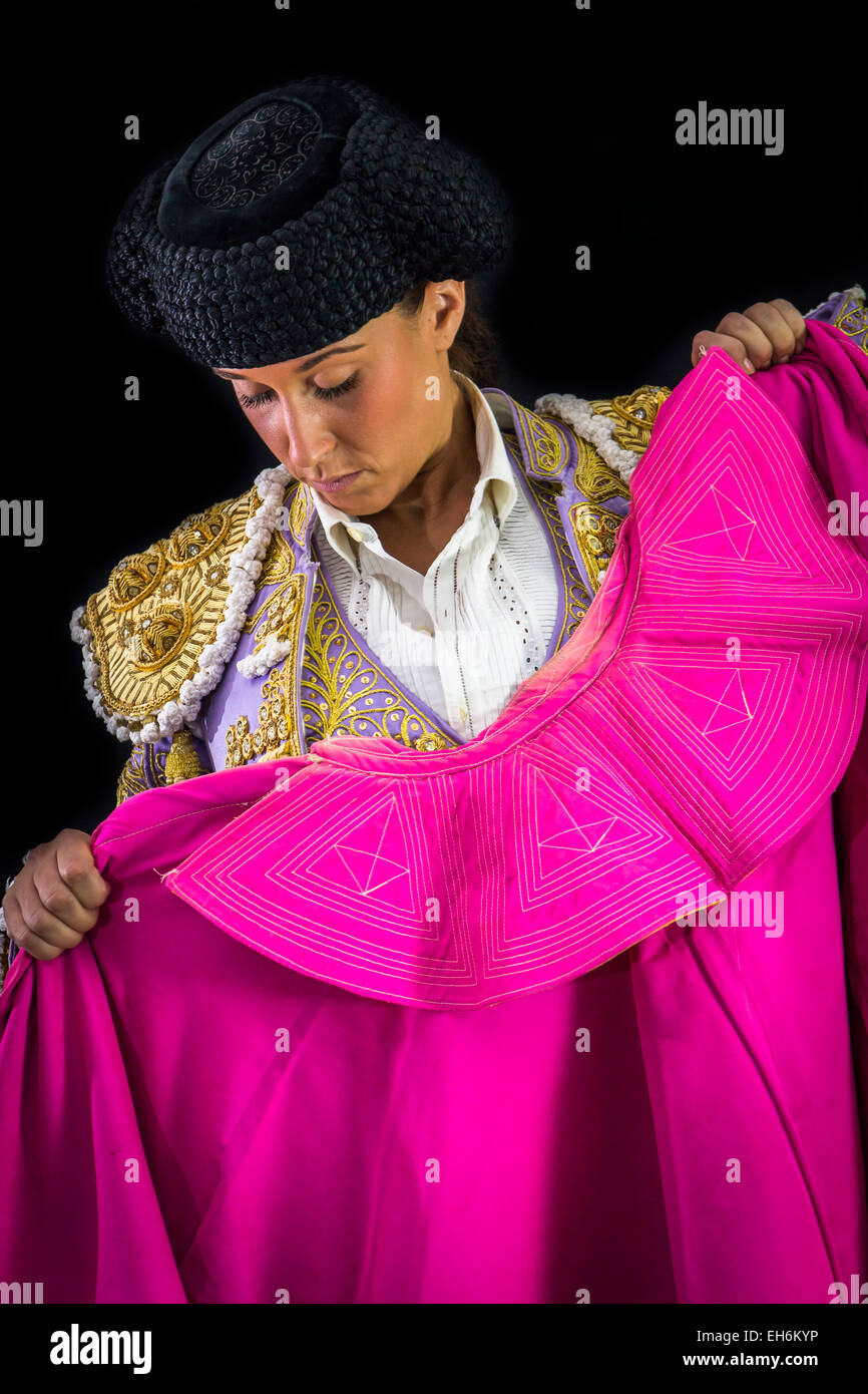 Woman bullfighter holding capote pink on black background Stock Photo ...