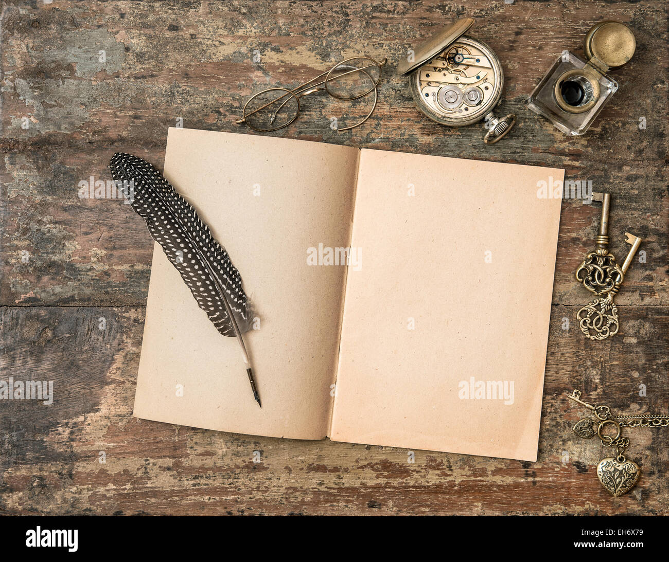 Open book and vintage writing accessories. Feather pen and inkwell on ...