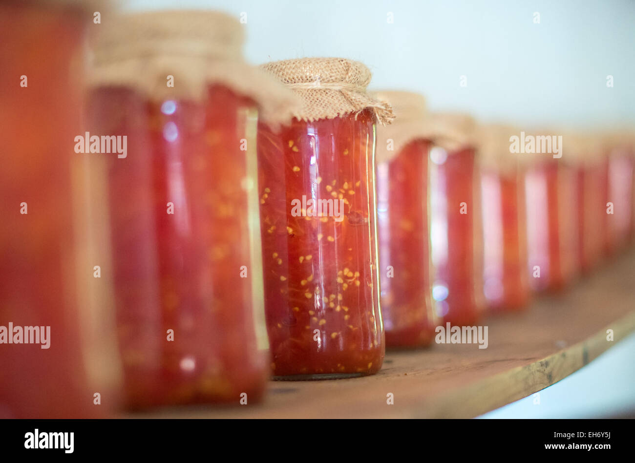 Canned tomatoes in glass jars on wooden shelf Stock Photo - Alamy