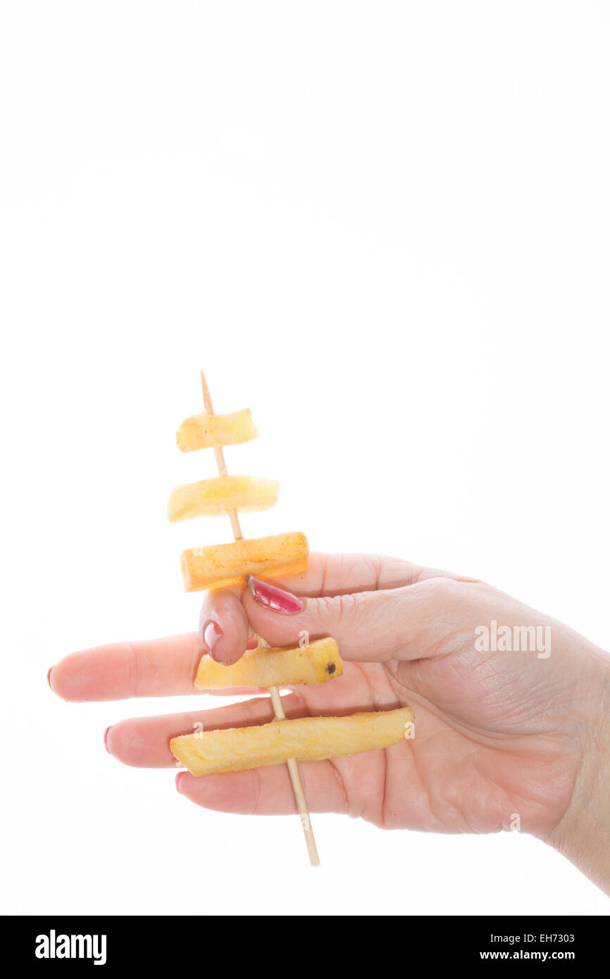 Female hand holding French fries on a stick in white background Stock ...