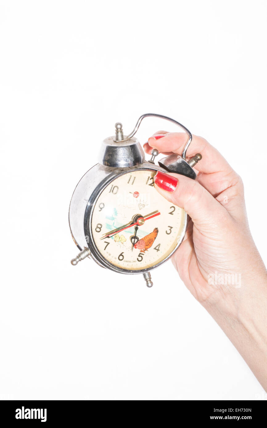 Hand holding a vintage clock over white background Stock Photo - Alamy