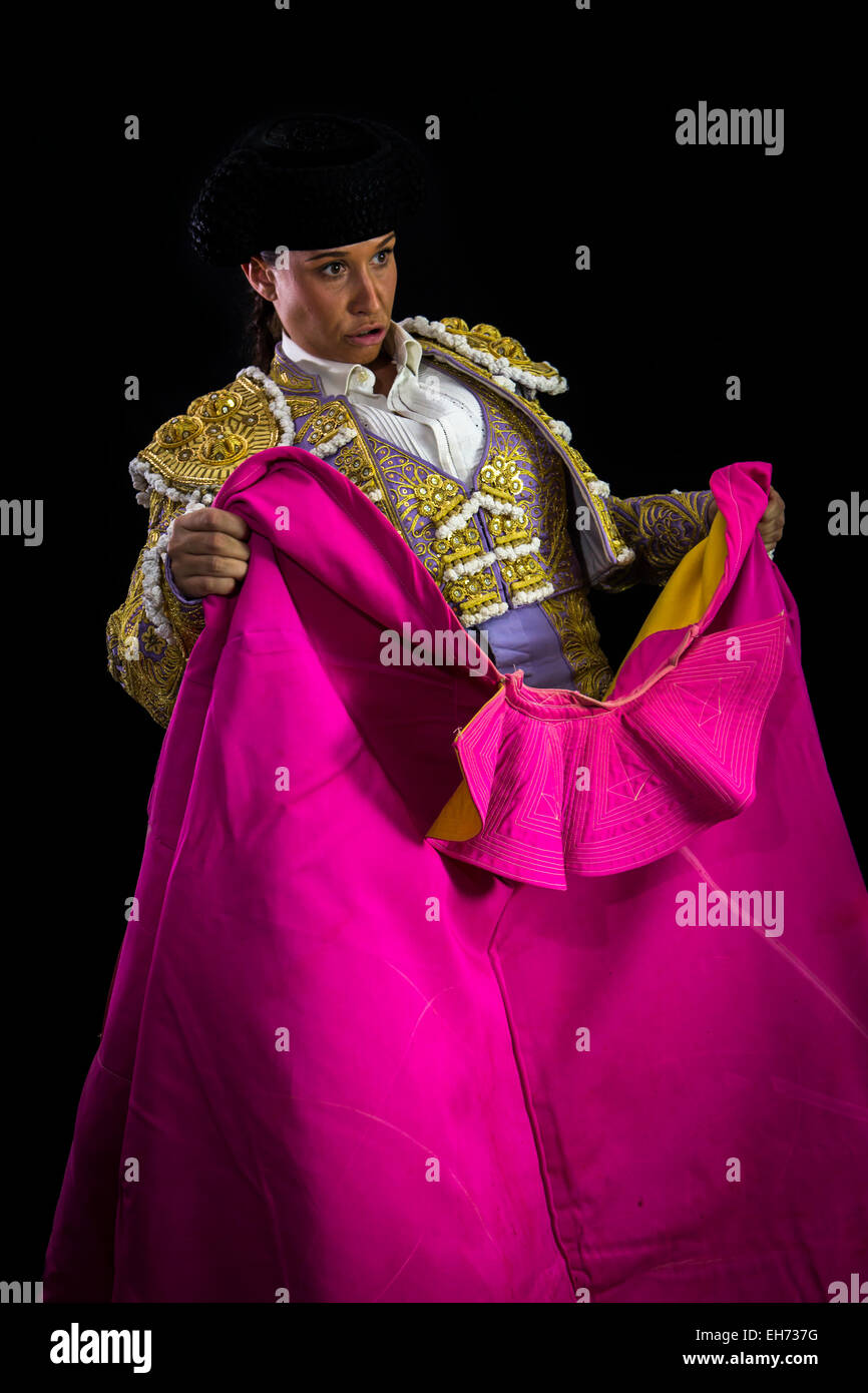 Woman bullfighter holding capote pink on black background Stock Photo ...