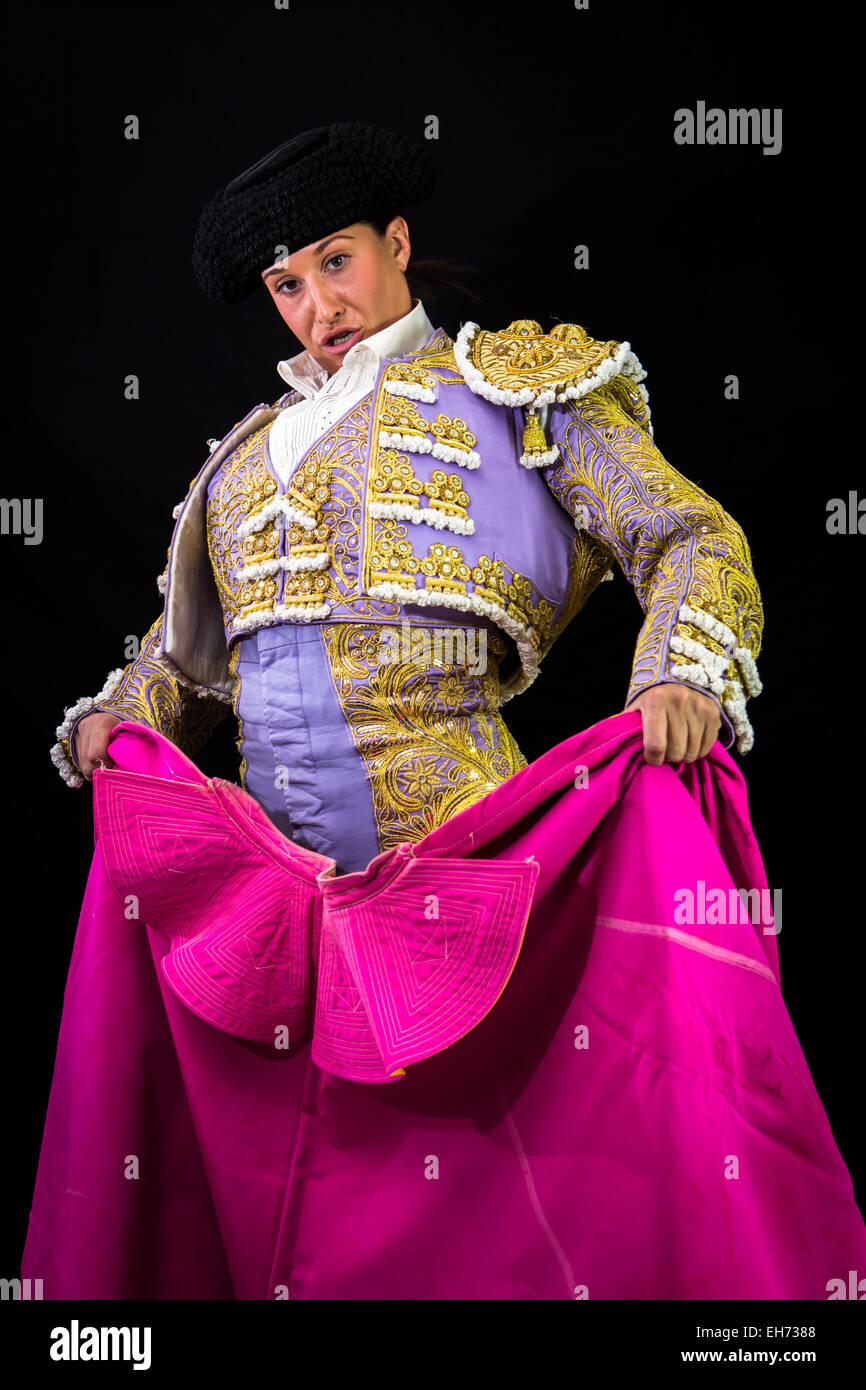 Woman bullfighter holding capote pink on black background Stock Photo ...