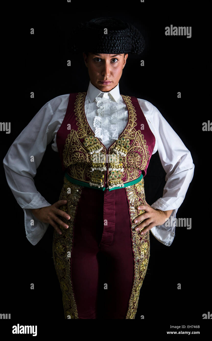 Woman bullfighter by dressing in a costume of old lighting on a black ...
