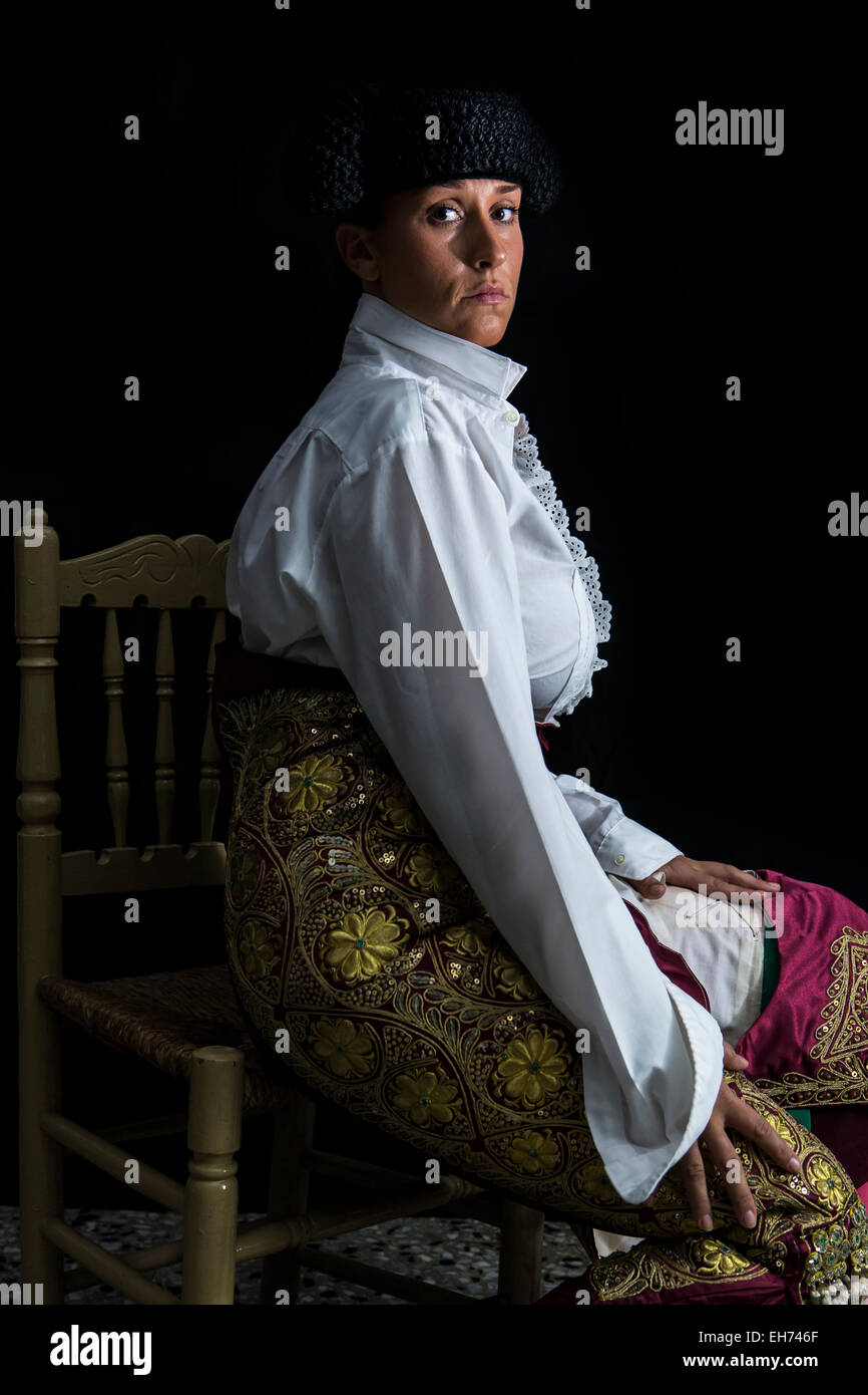 Woman bullfighter sitting on black background Stock Photo - Alamy