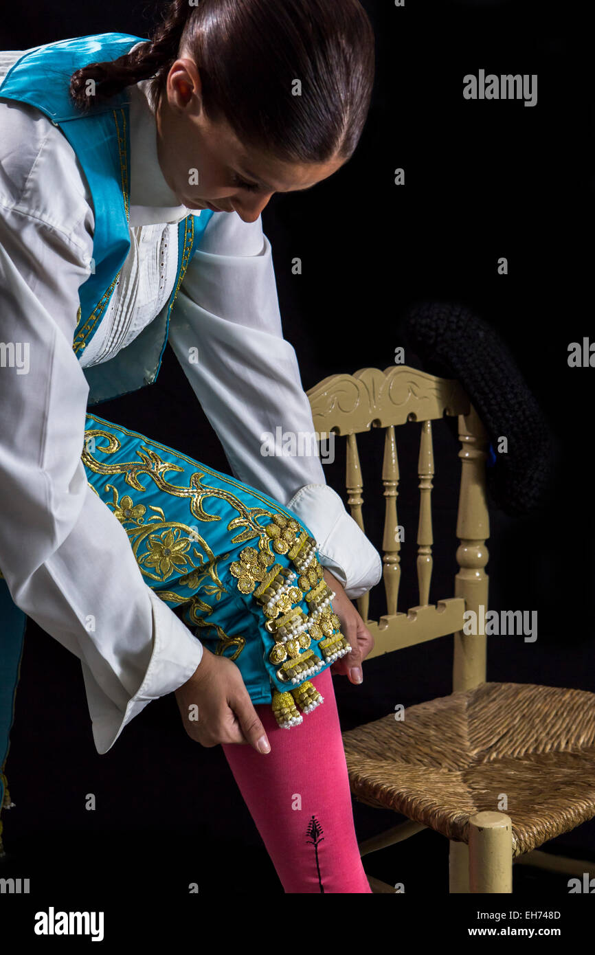 Woman bullfighter by dressing with vest on your back on a black ...