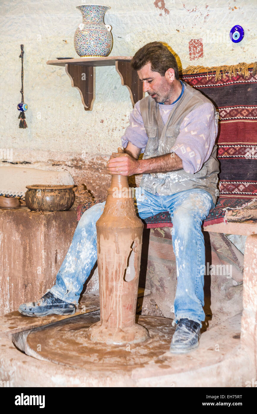 Local male craftsman in a pottery workshop working on throwing a large ...