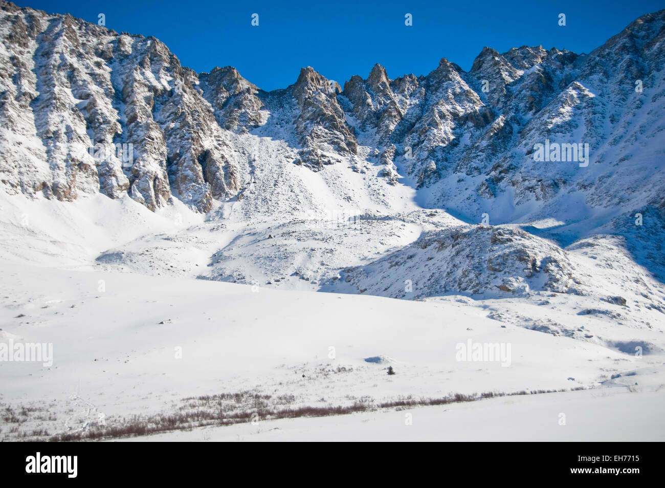 A cliff face is covered with snow in the Colorado Rockies in a winter ...