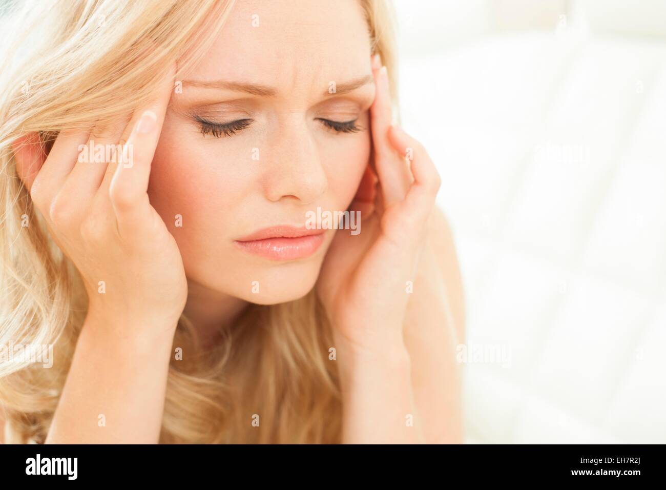 Woman touching head Stock Photo - Alamy