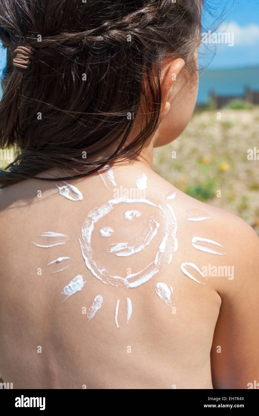 Girl with suncream on back Stock Photo - Alamy
