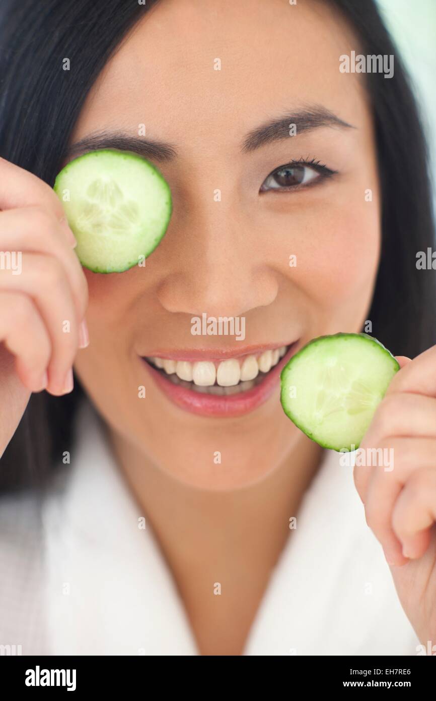 Woman holding cucumber slices Stock Photo - Alamy