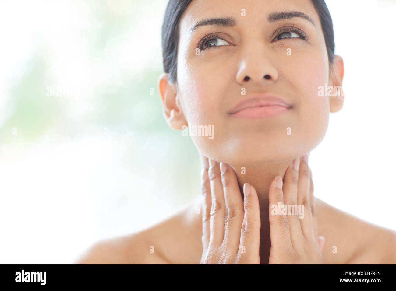 Woman touching her neck Stock Photo - Alamy