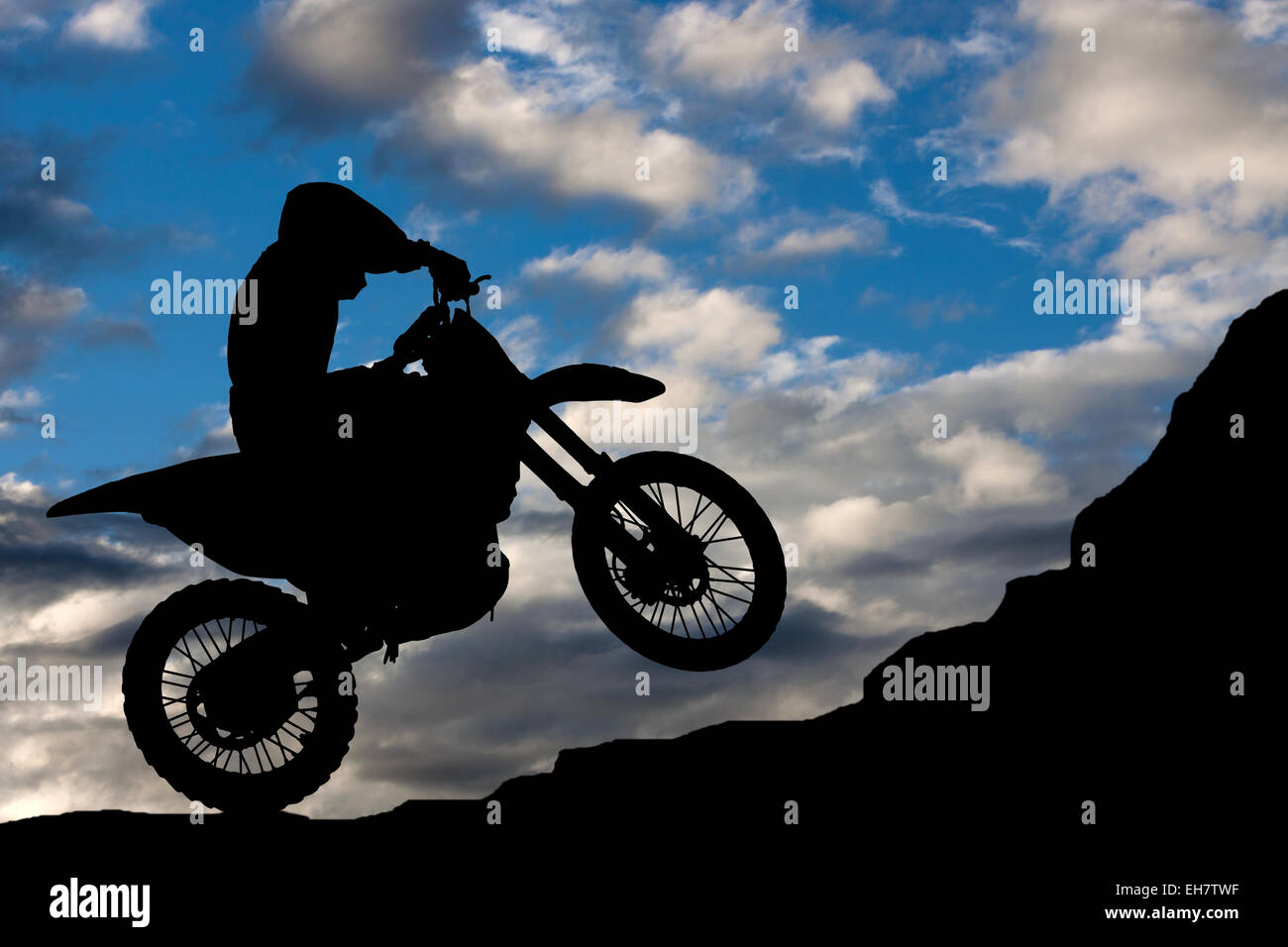 Motocross - silhouette with a rock and blue sky Stock Photo - Alamy