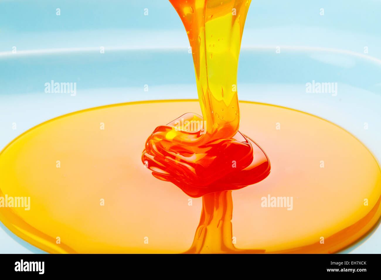 Thick golden liquid being poured Stock Photo - Alamy
