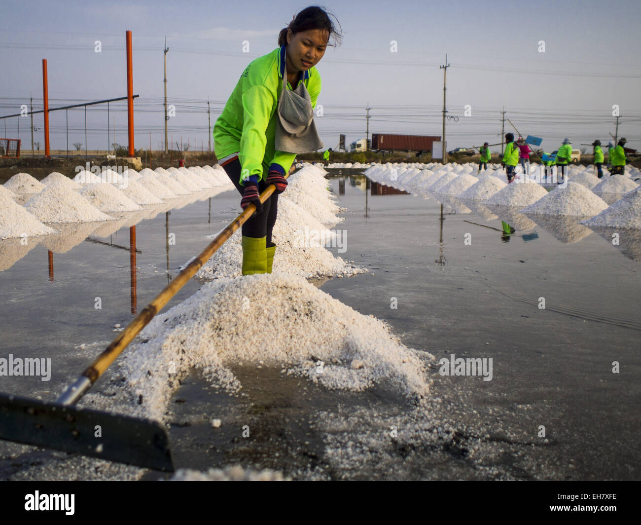 Na Khok, Samut Sakhon, Thailand. 9th Mar, 2015. Workers rake salt into ...