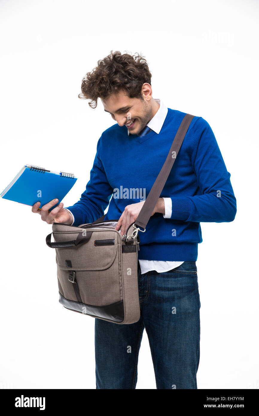 Smiling young man standing with bag and notebook Stock Photo - Alamy
