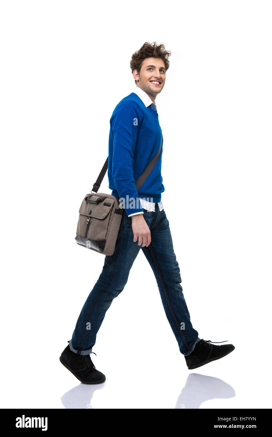 Full length portrait of a happy young man walking over white background ...