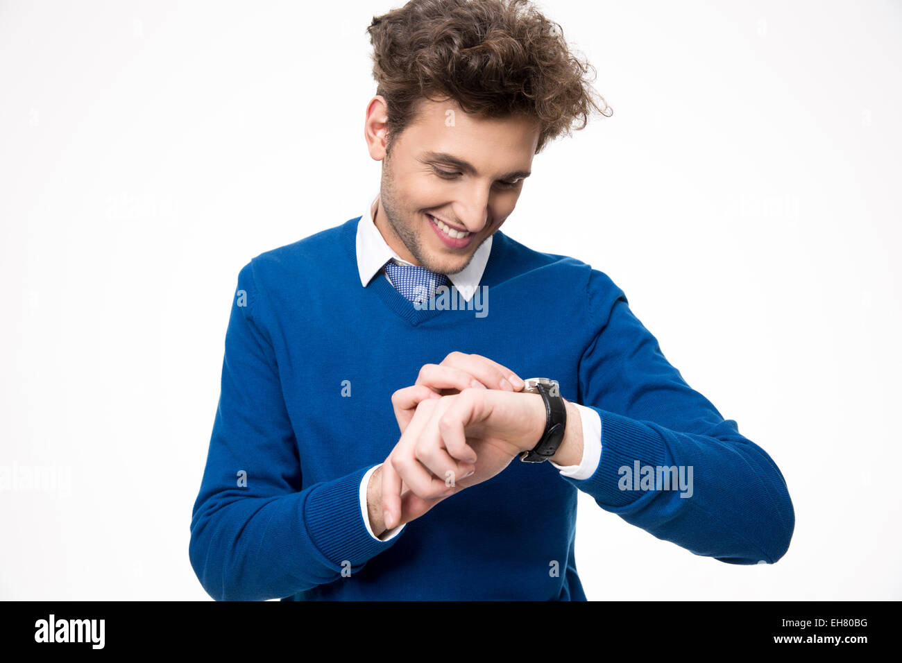 Happy businessman looking at watch over white background Stock Photo ...
