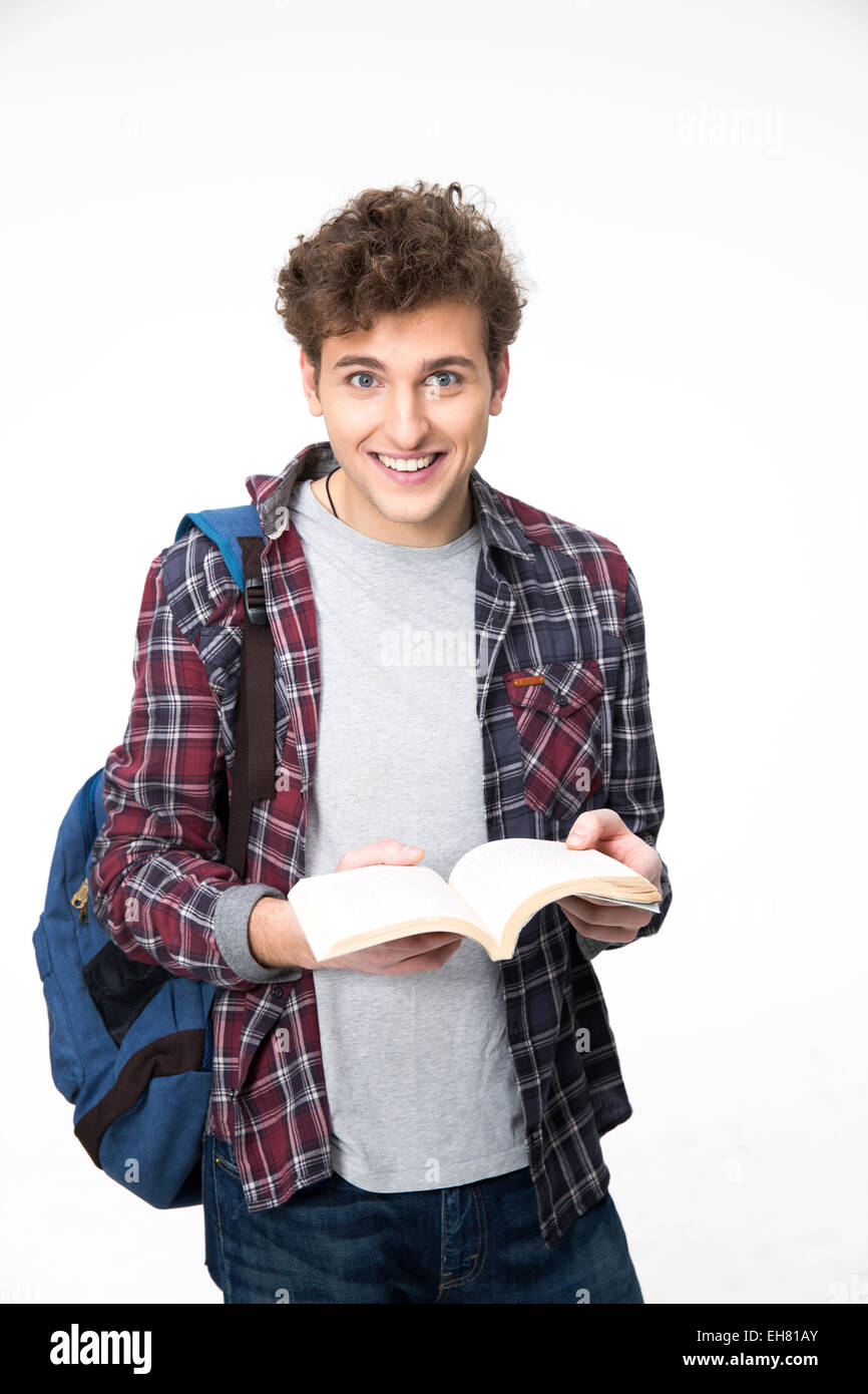 Smiling male student standing with opened book over gray background ...