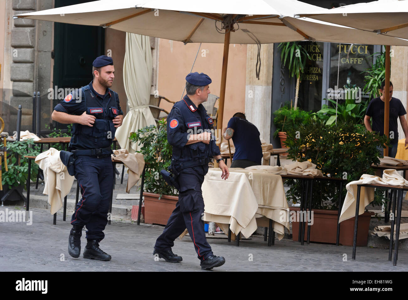Two armed members of the Carabinieri walking along a street in Rome ...