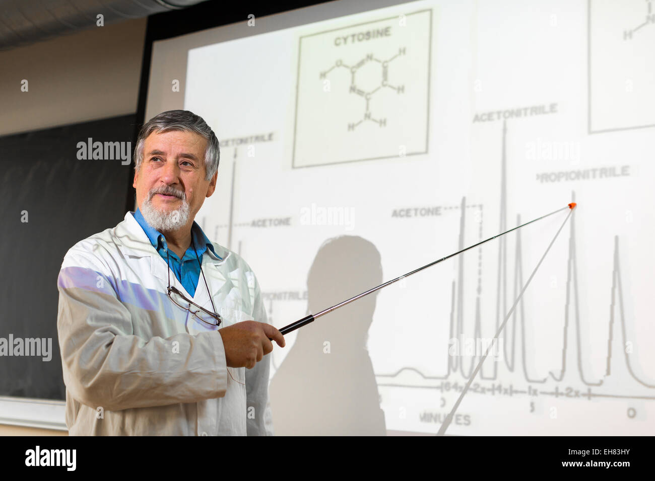 Senior chemistry professor giving a lecture in front of classroom full ...