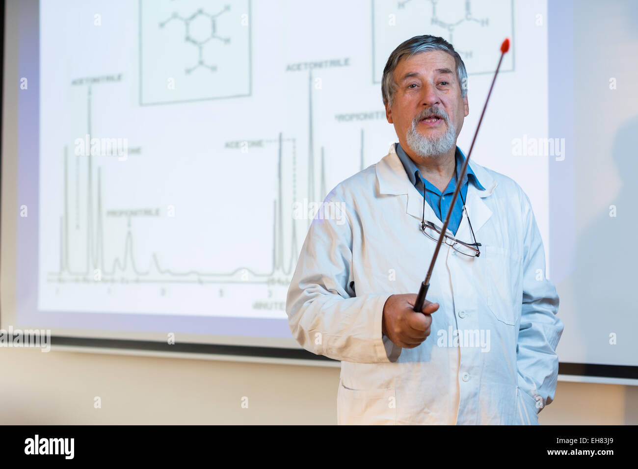 Senior chemistry professor giving a lecture in front of classroom full ...