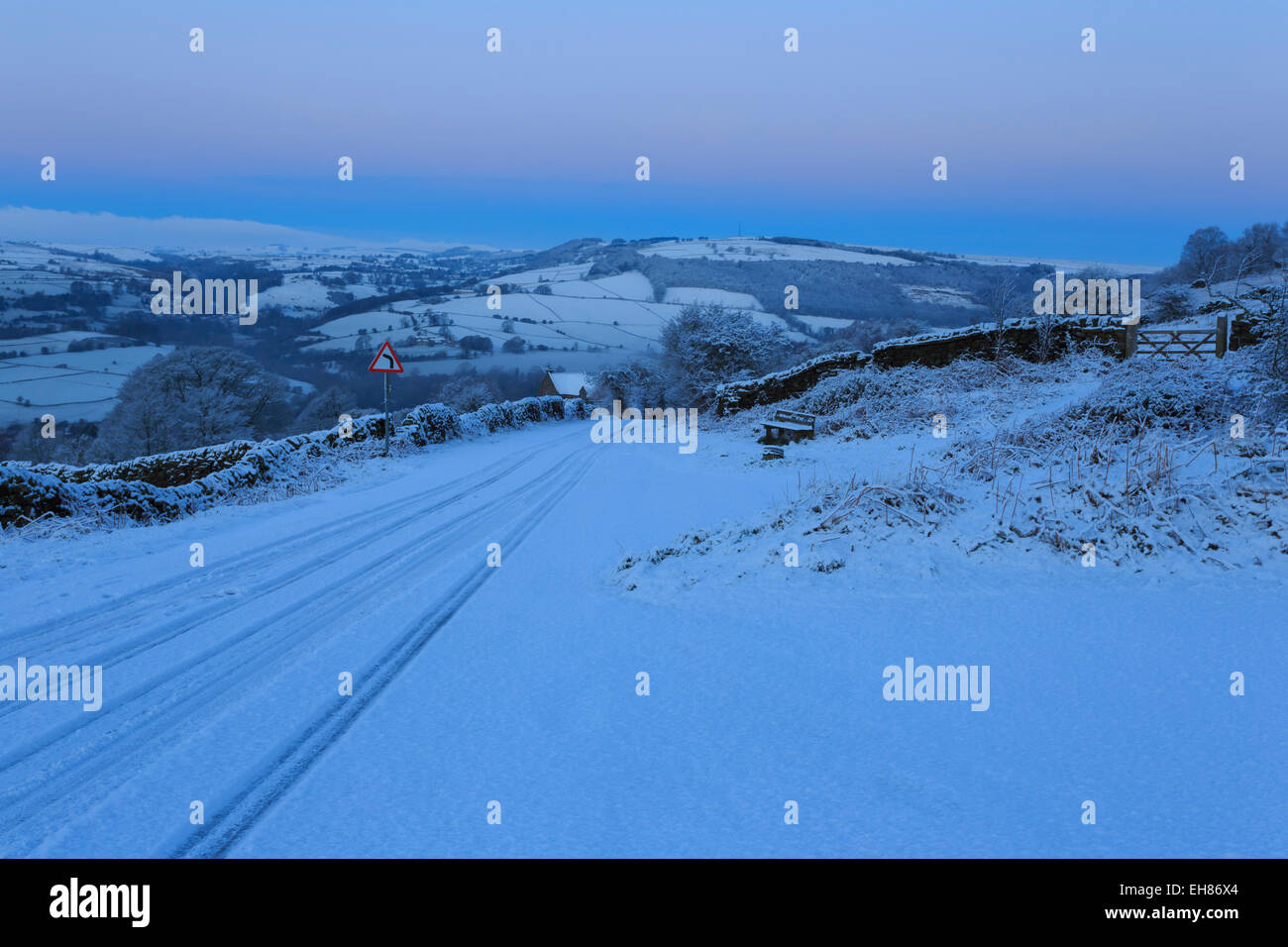 Fresh snow on country lane, winter pre-dawn blue hour, below Curbar ...