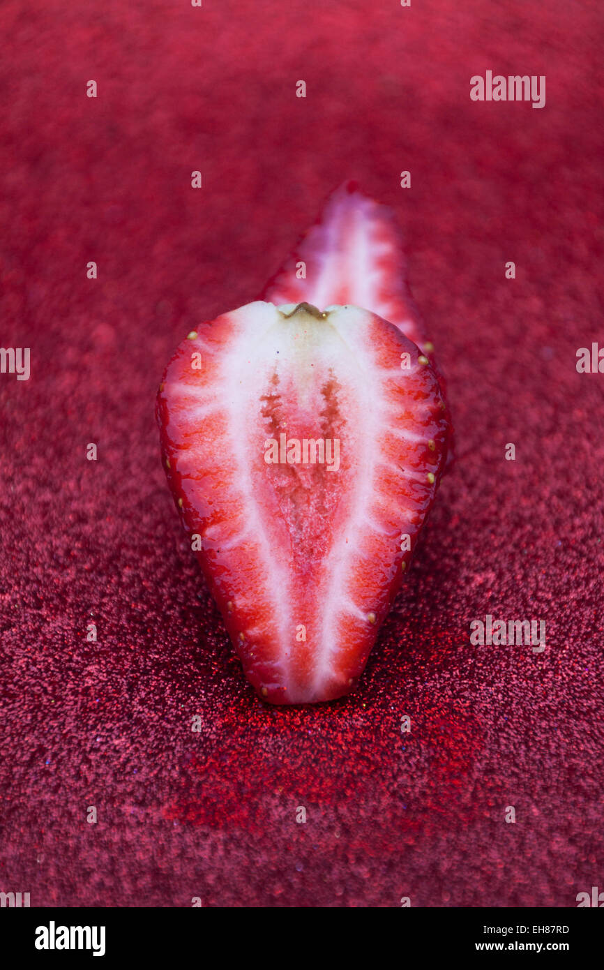 An open strawberry on a red glittery background bokeh Stock Photo - Alamy
