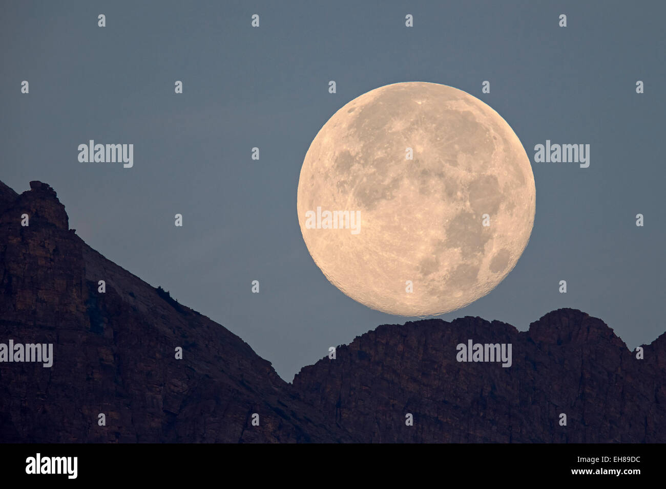 Full moon setting above a ridge, Glacier National Park, Montana, United ...