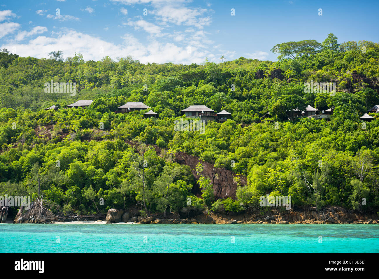 View of Seychelles coastline with houses in the forest. Horizontal shot ...