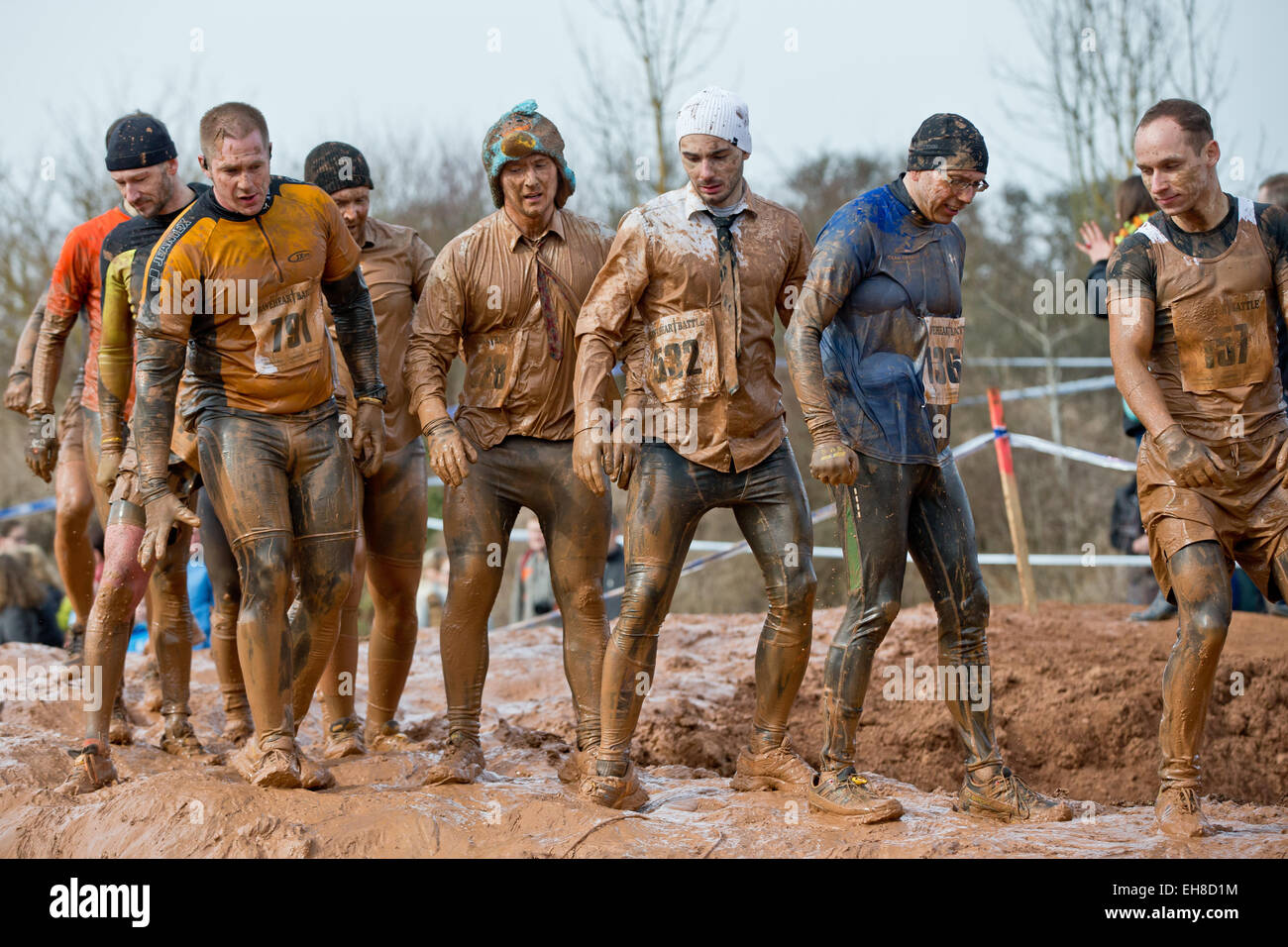 Participants look on at a mud pit obstacle during the extreme course ...