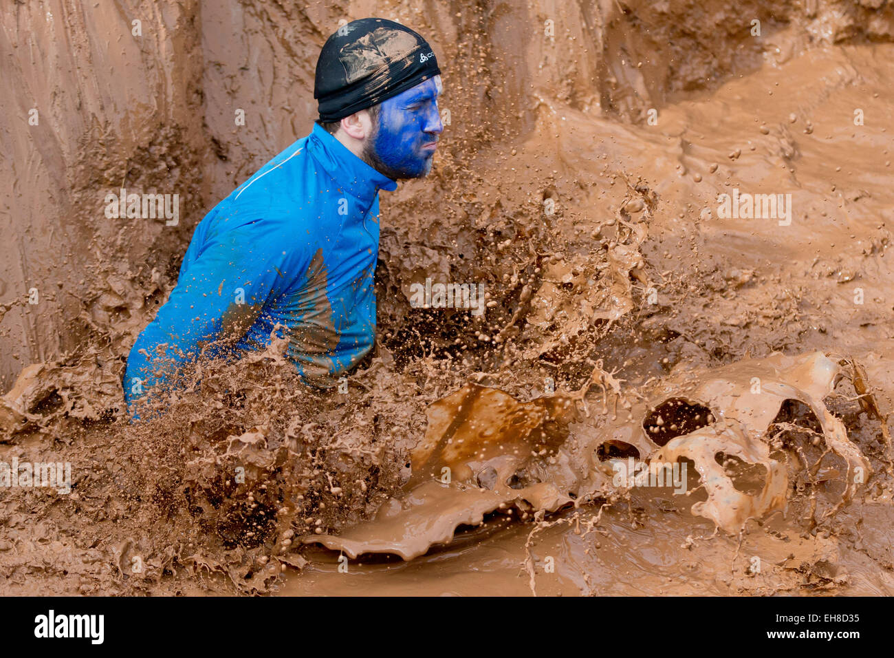 A participant tries to overcome a mud pit during the extreme course ...