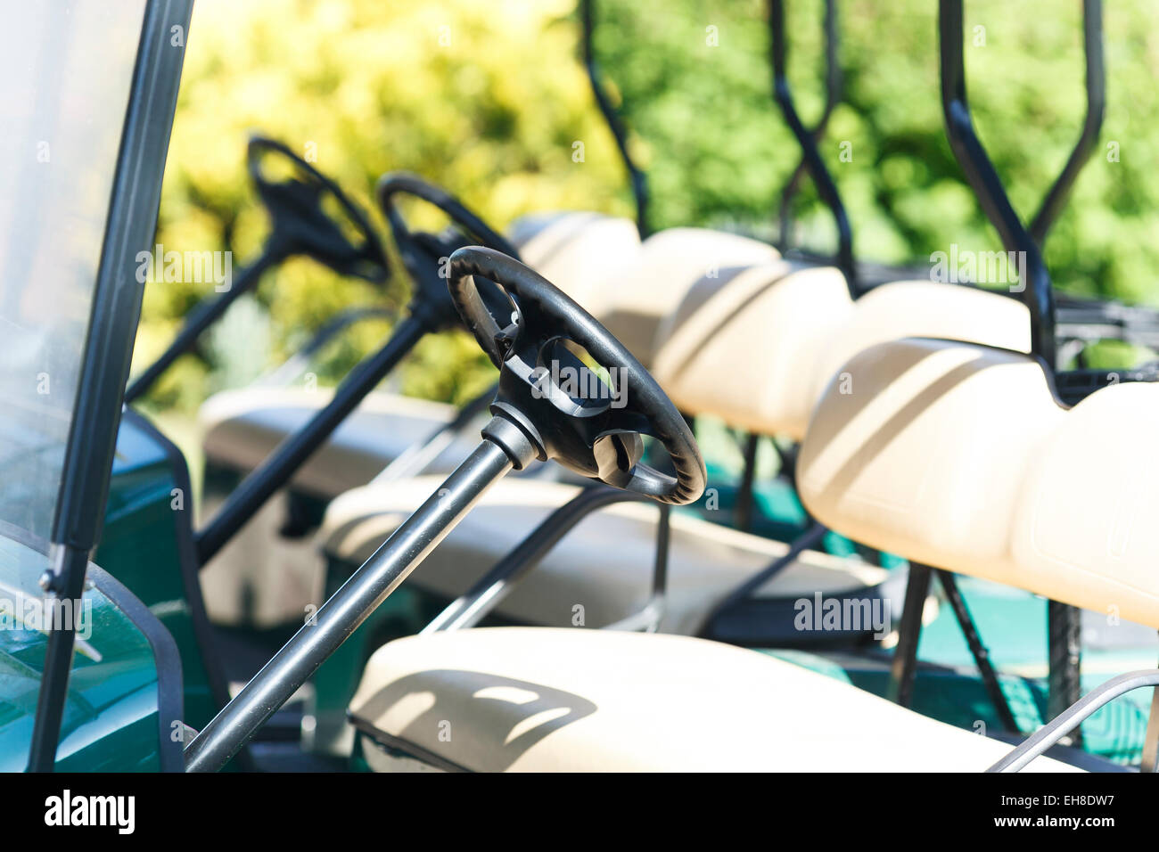 golf buggy x 3 close up inside steering wheels Stock Photo - Alamy