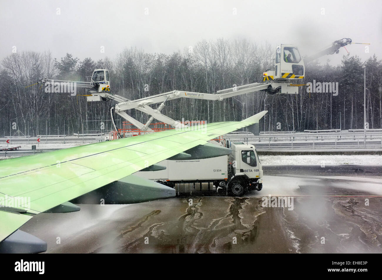A wing covered in green deicing liquid while being deiced at Frankfurt ...