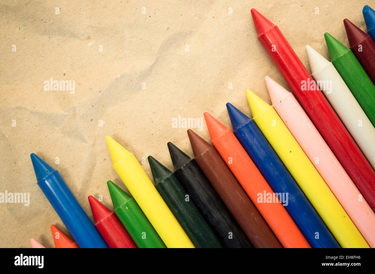 set of lined up colored wax crayons close up on a natural recycled ...