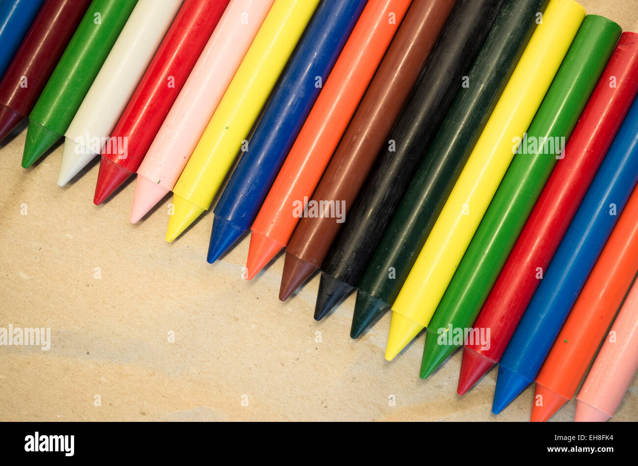 set of lined up colored wax crayons close up on a natural recycled ...