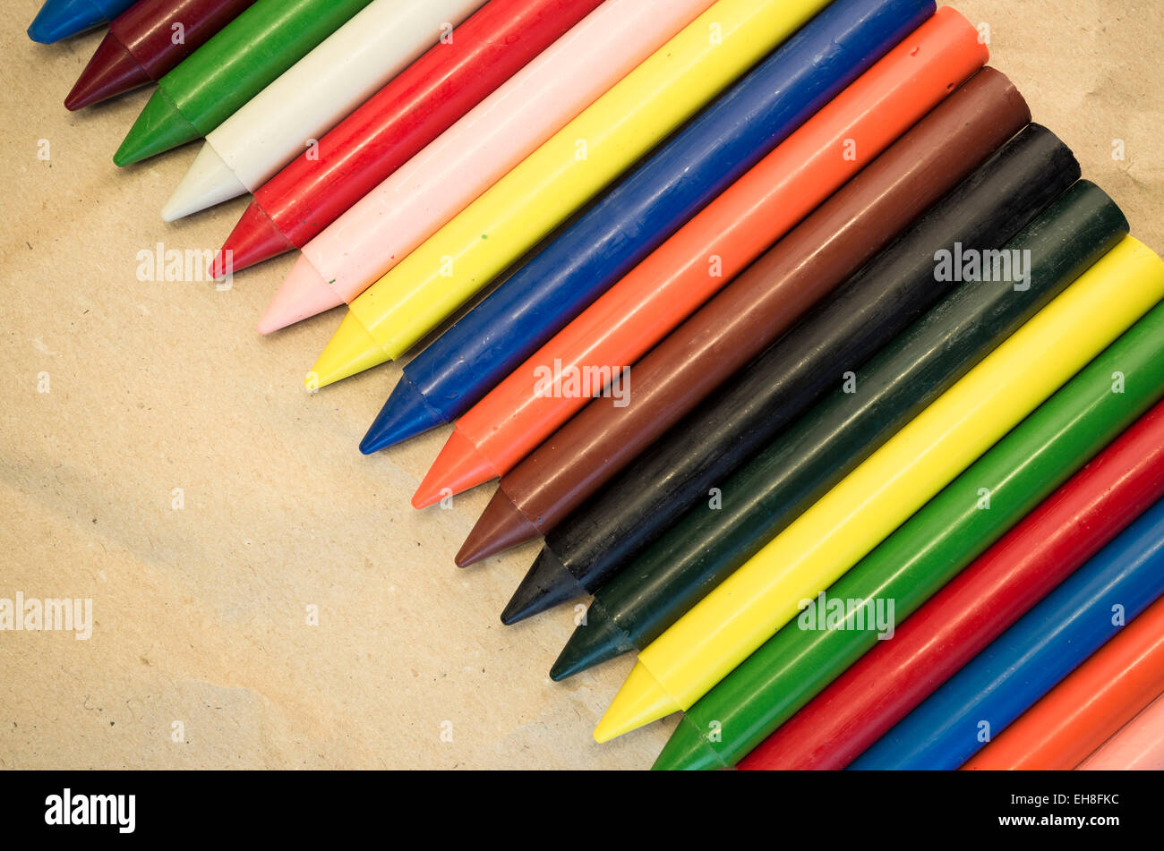 set of lined up colored wax crayons close up on a natural recycled ...