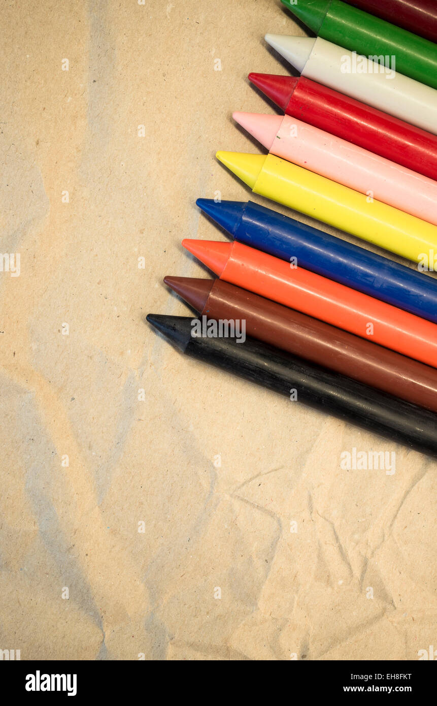 set of lined up colored wax crayons close up on a natural recycled ...