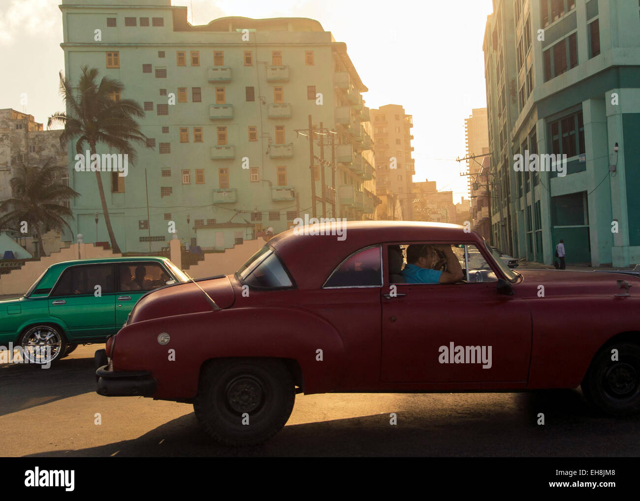 Two american classic cars in Havana, Cuba driving in sunset Stock Photo ...