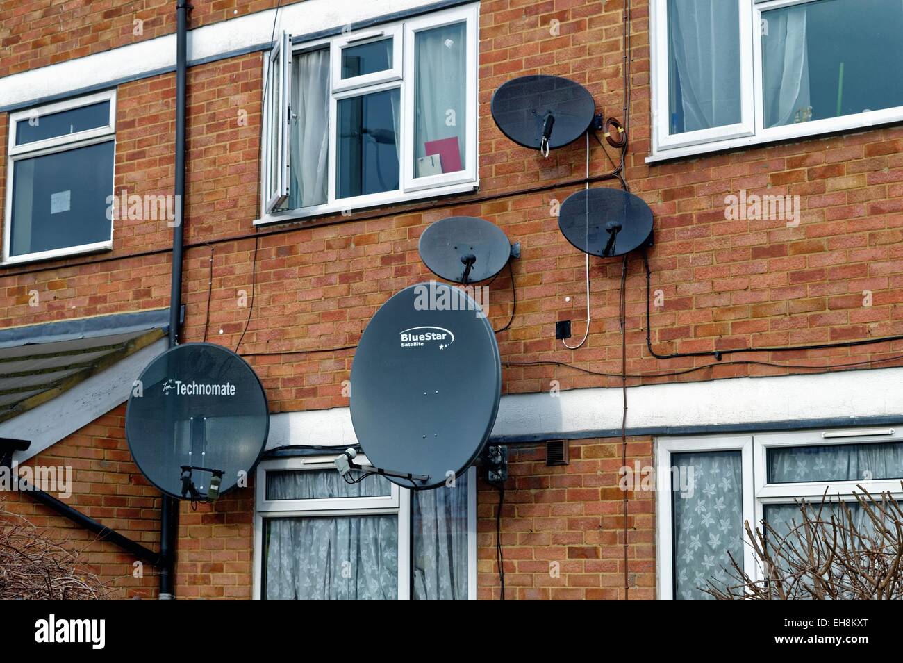 Five satellite dishes on the side of housing in Southall West London UK ...