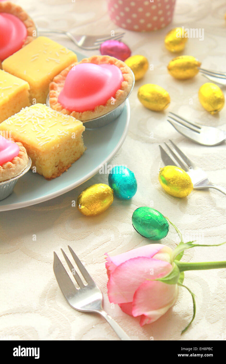 Easter table with sweet eggs, pink roses and fresh cakes Stock Photo ...