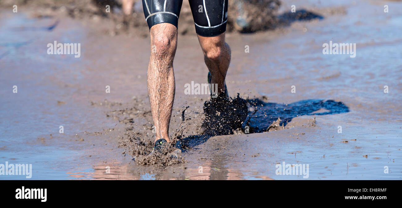 Man running in mud puddle Stock Photo - Alamy