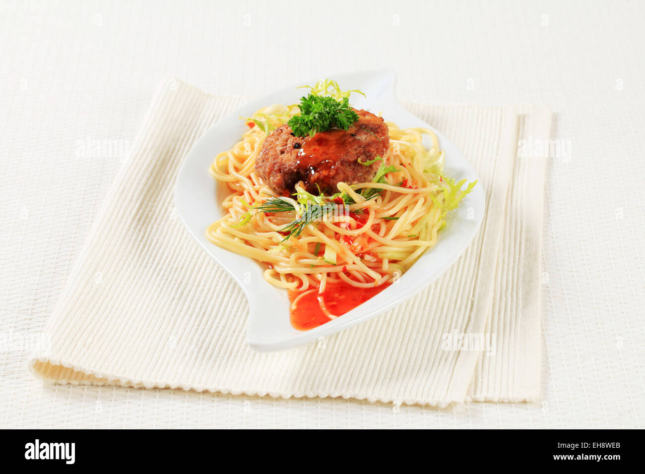 Meat patty with spaghetti and spicy sauce Stock Photo - Alamy