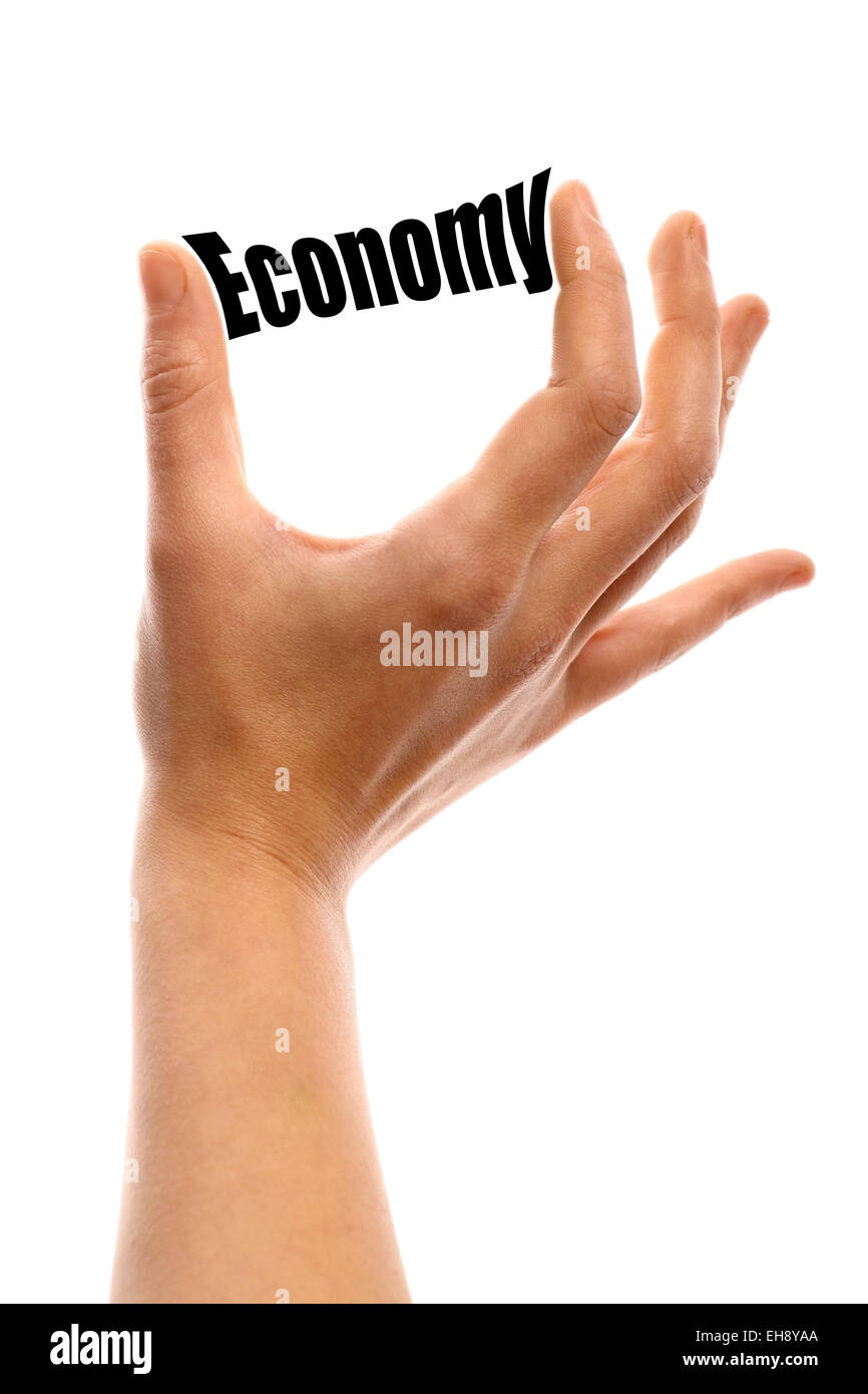 Vertical shot of a hand holding the word "Economy" between two fingers ...