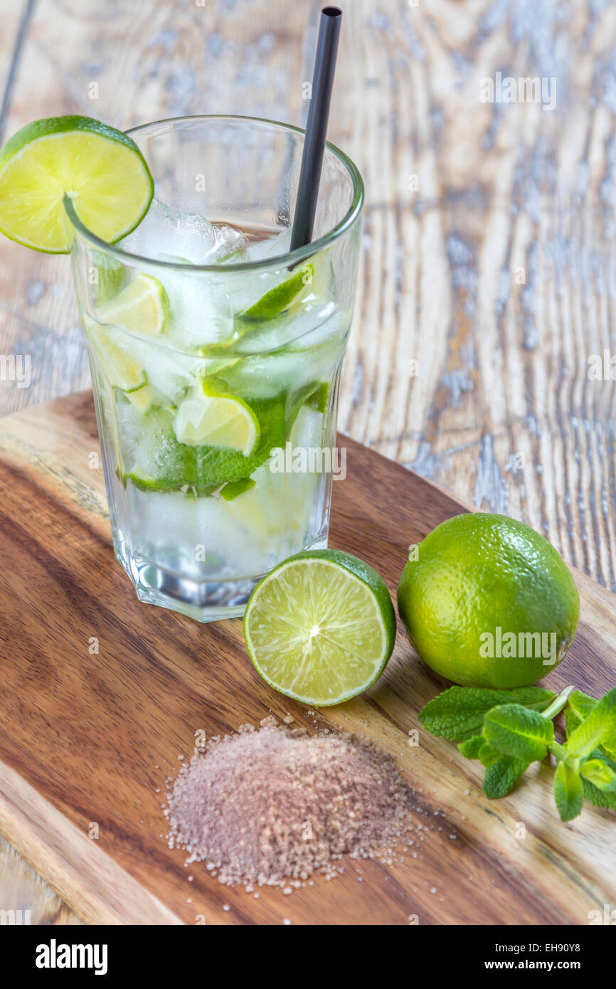 Glass with Mojito Cocktail and its ingredients on rustic wooden table ...