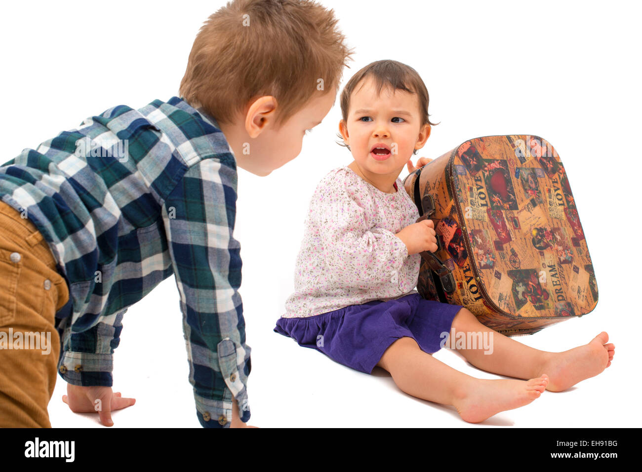 Two little kids disputing a suitcase Stock Photo - Alamy