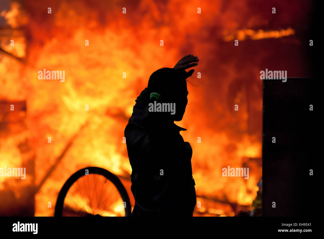 A man is watching as a fire accident burns a dense neighborhood in ...